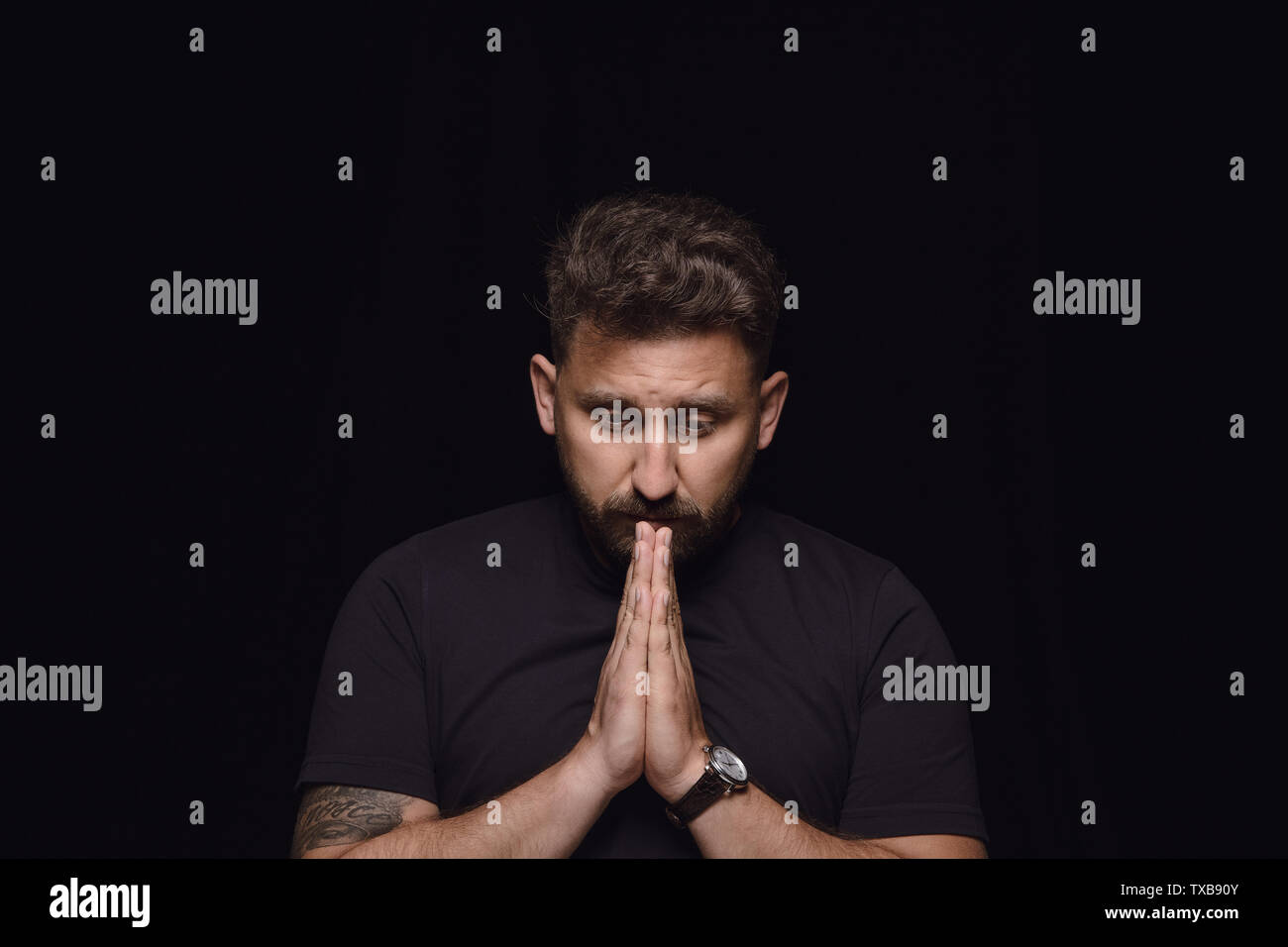 Close up portrait of young man isolated on black studio background ...