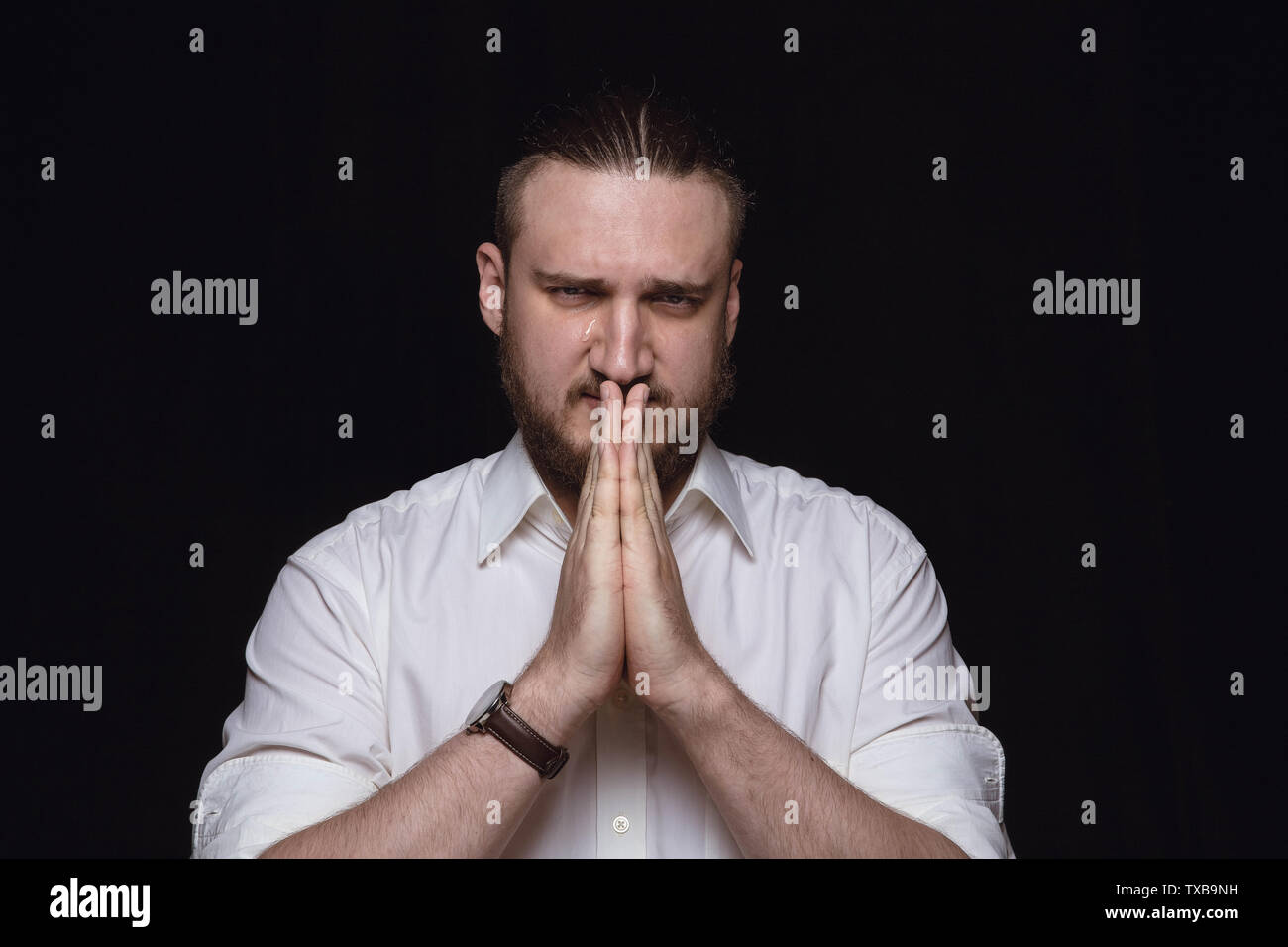 Close up portrait of young man isolated on black studio background ...