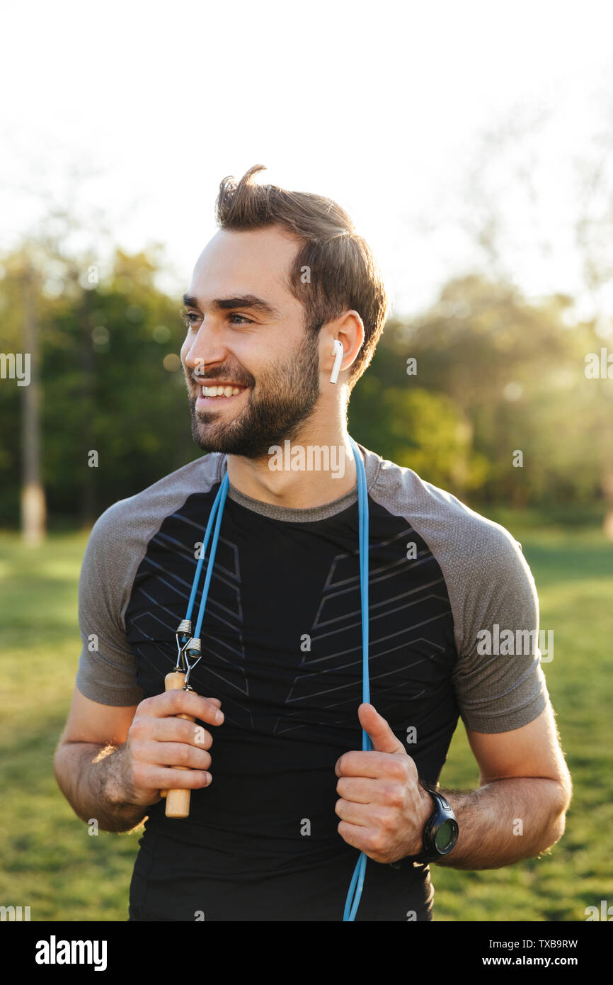 Image of a handsome young strong sports man posing outdoors at the ...