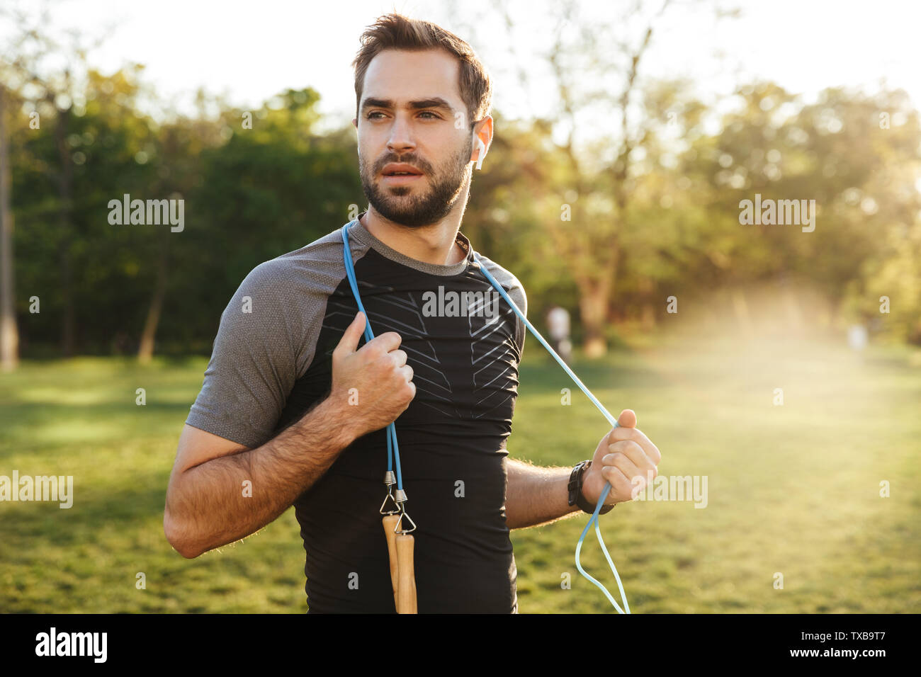 Image of a handsome young strong sports man posing outdoors at the ...