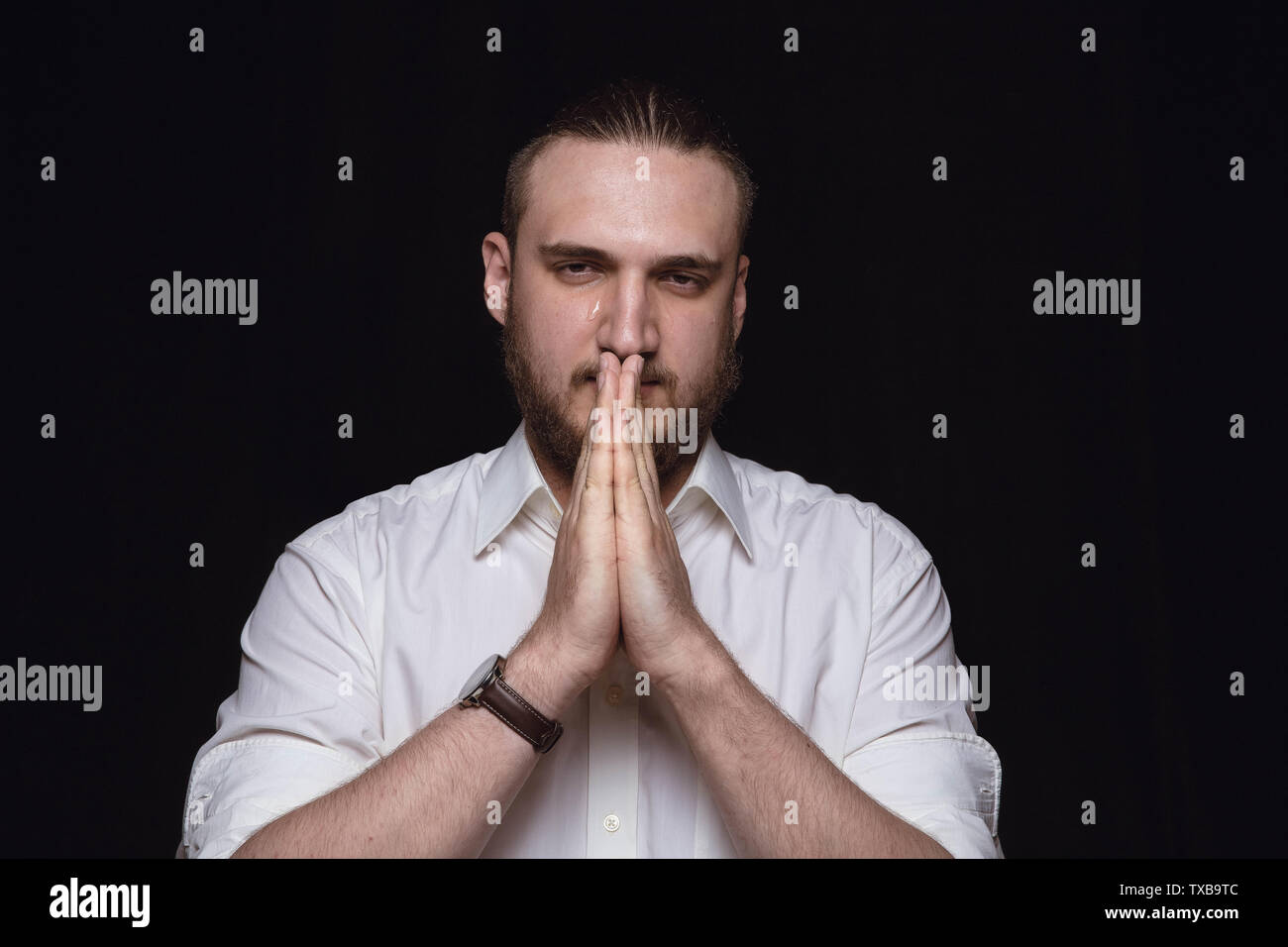 Close up portrait of young man isolated on black studio background ...