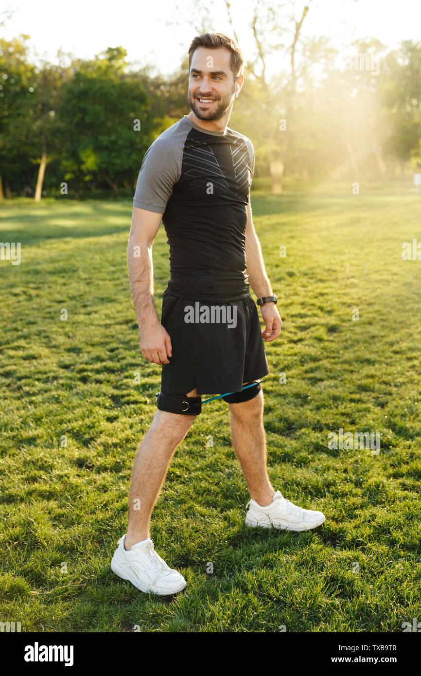 Image of a handsome young strong sports man posing outdoors at the ...