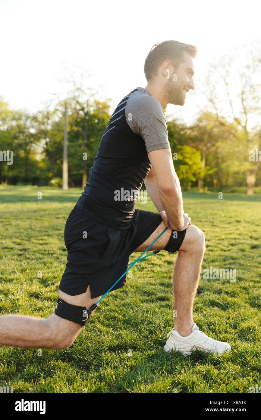 Image of a handsome young strong sports man posing outdoors at the ...