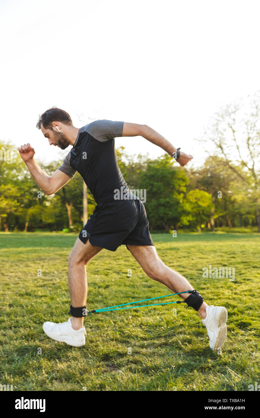 Image of a handsome young strong sports man posing outdoors at the ...