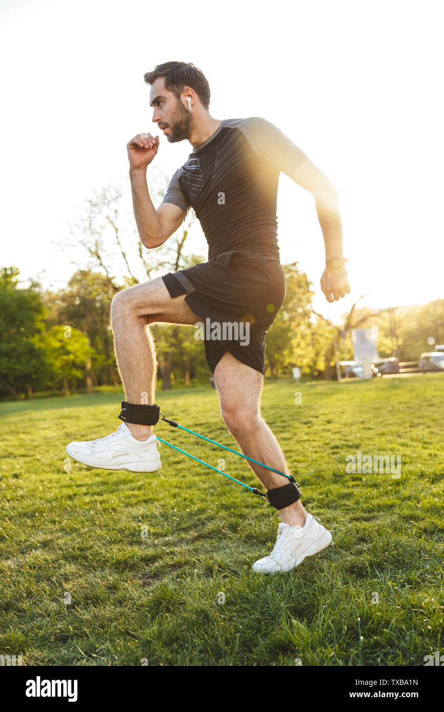 Image of a handsome young strong sports man posing outdoors at the ...