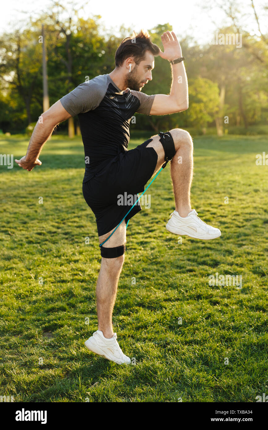 Image of a handsome young strong sports man posing outdoors at the ...