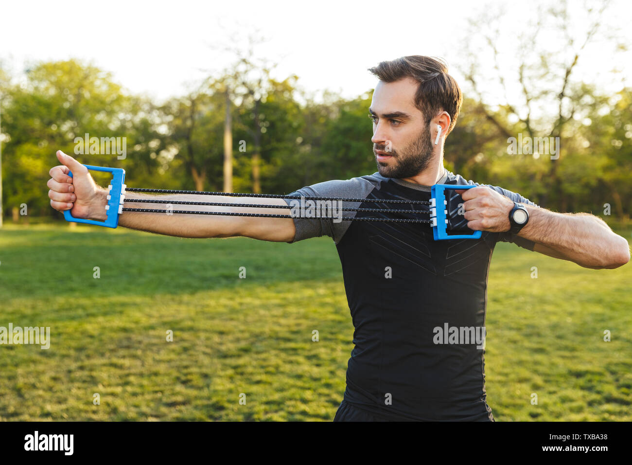 Image of a handsome young strong sports man posing outdoors at the ...