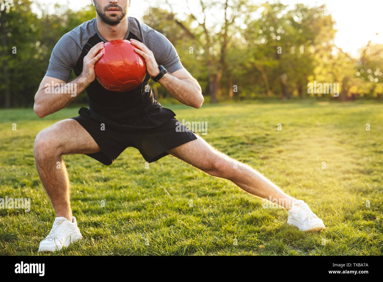 Image of a handsome young strong sports man posing outdoors at the ...