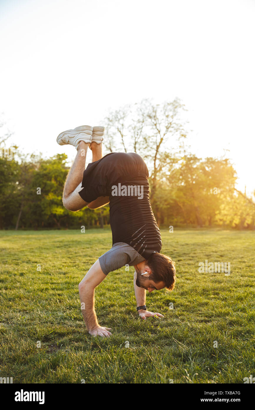 Image of a handsome young strong sports man posing outdoors at the ...