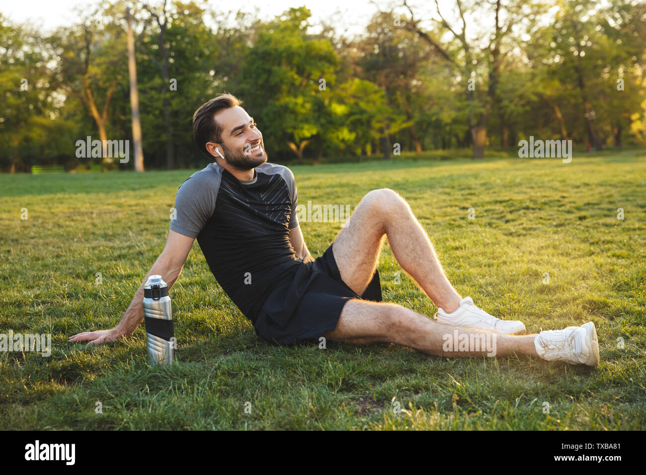 Image of a handsome young strong sports man posing outdoors at the ...