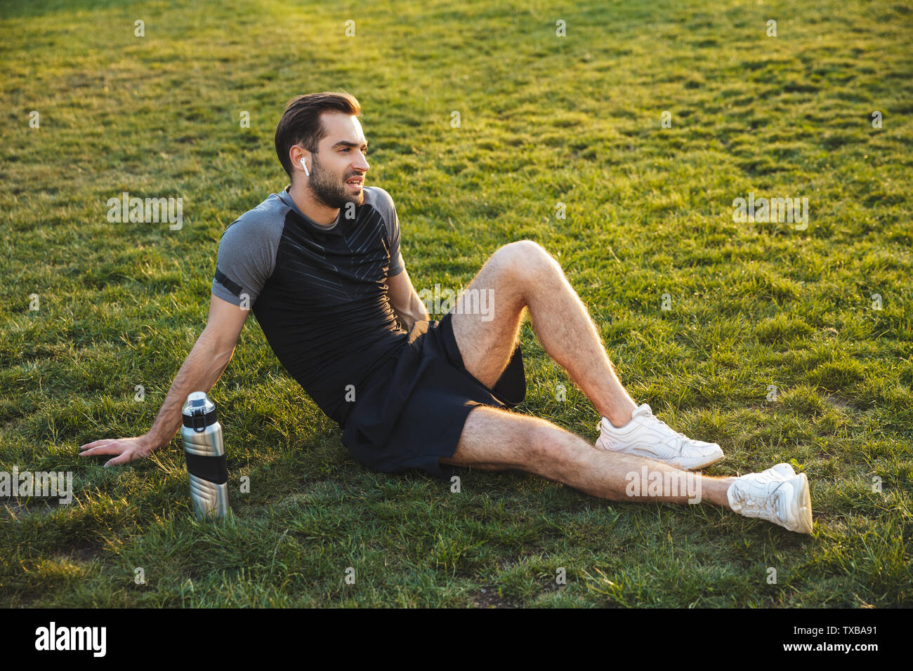Image of a handsome young strong sports man posing outdoors at the ...