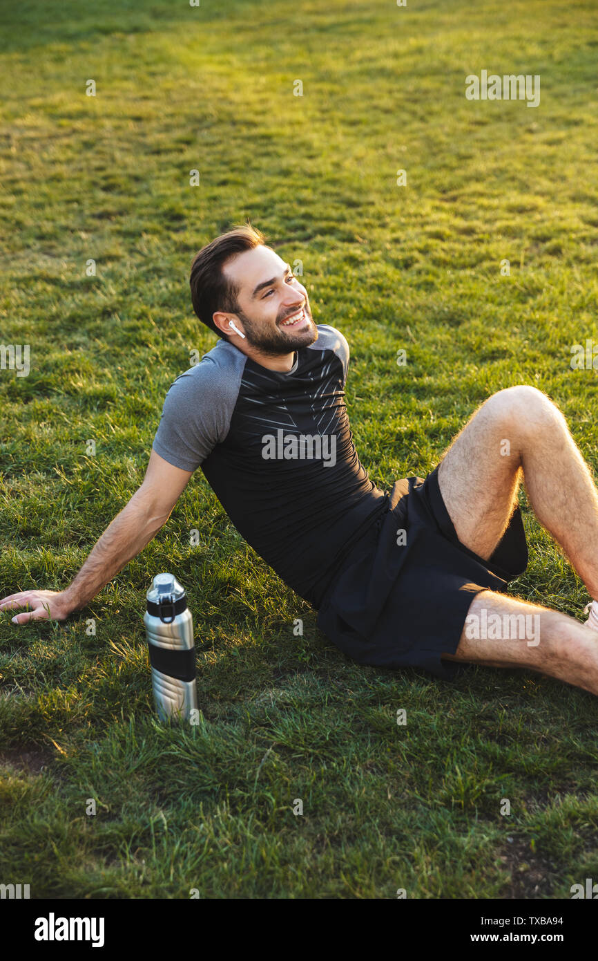 Image of a handsome young strong sports man posing outdoors at the ...