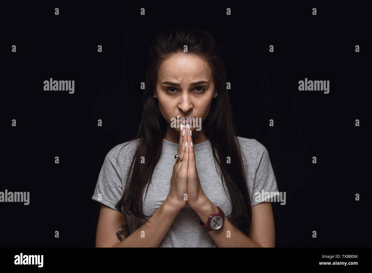 Close up portrait of young woman isolated on black studio background ...