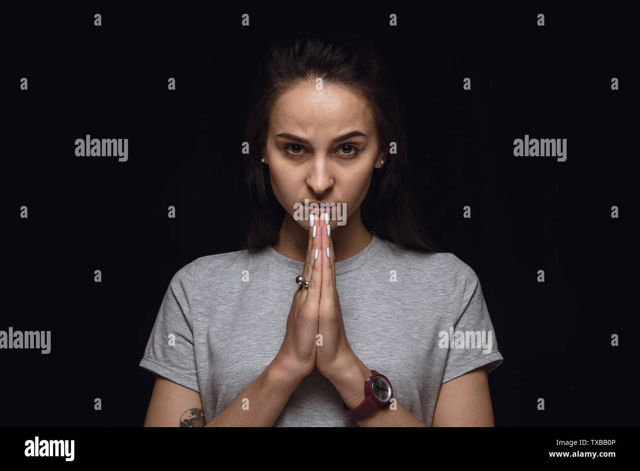 Close up portrait of young woman isolated on black studio background ...