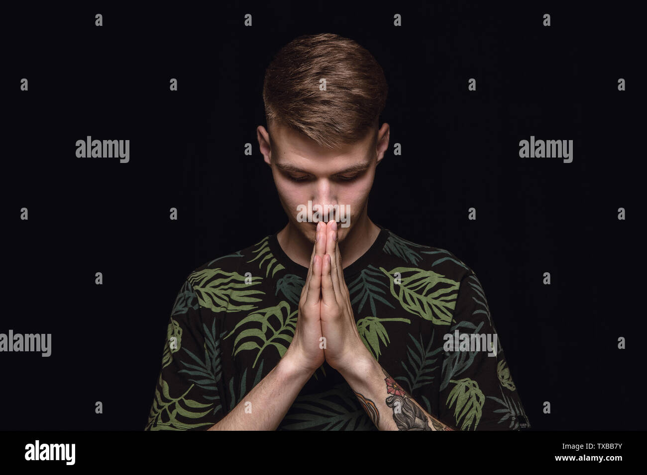 Close up portrait of young man isolated on black studio background ...