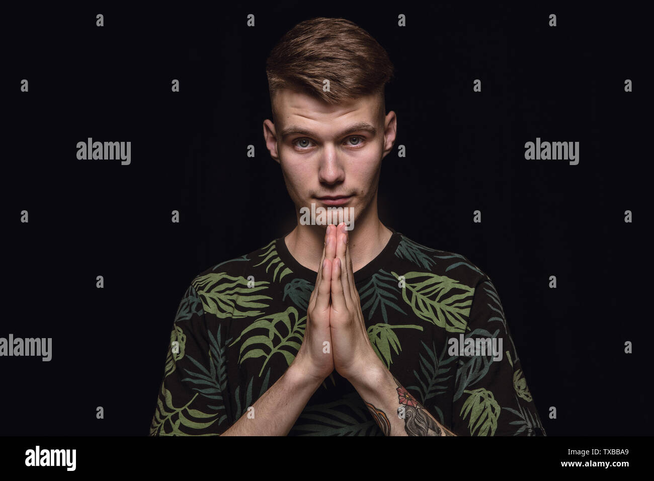 Close up portrait of young man isolated on black studio background ...
