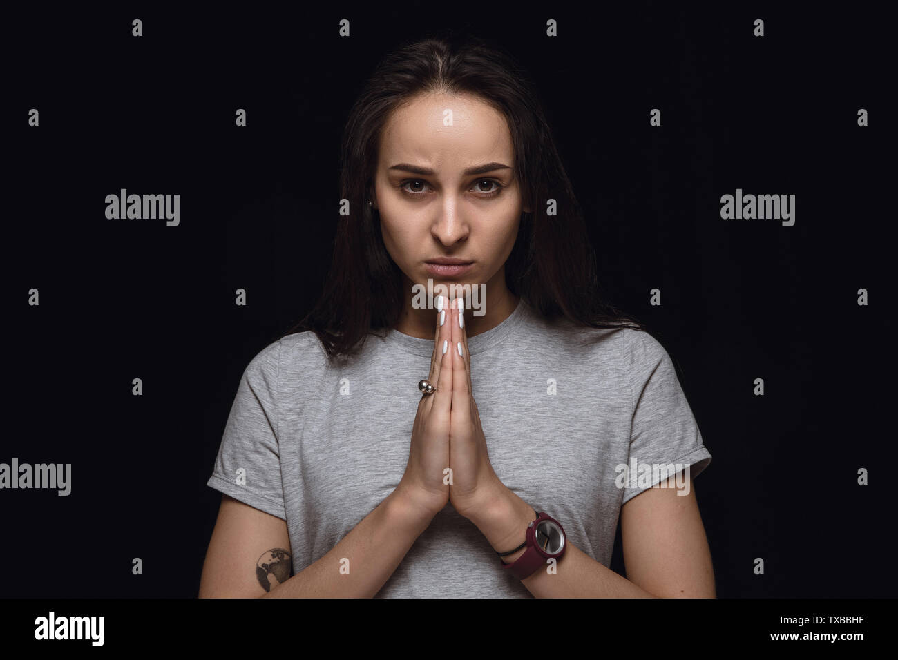 Close up portrait of young woman isolated on black studio background ...