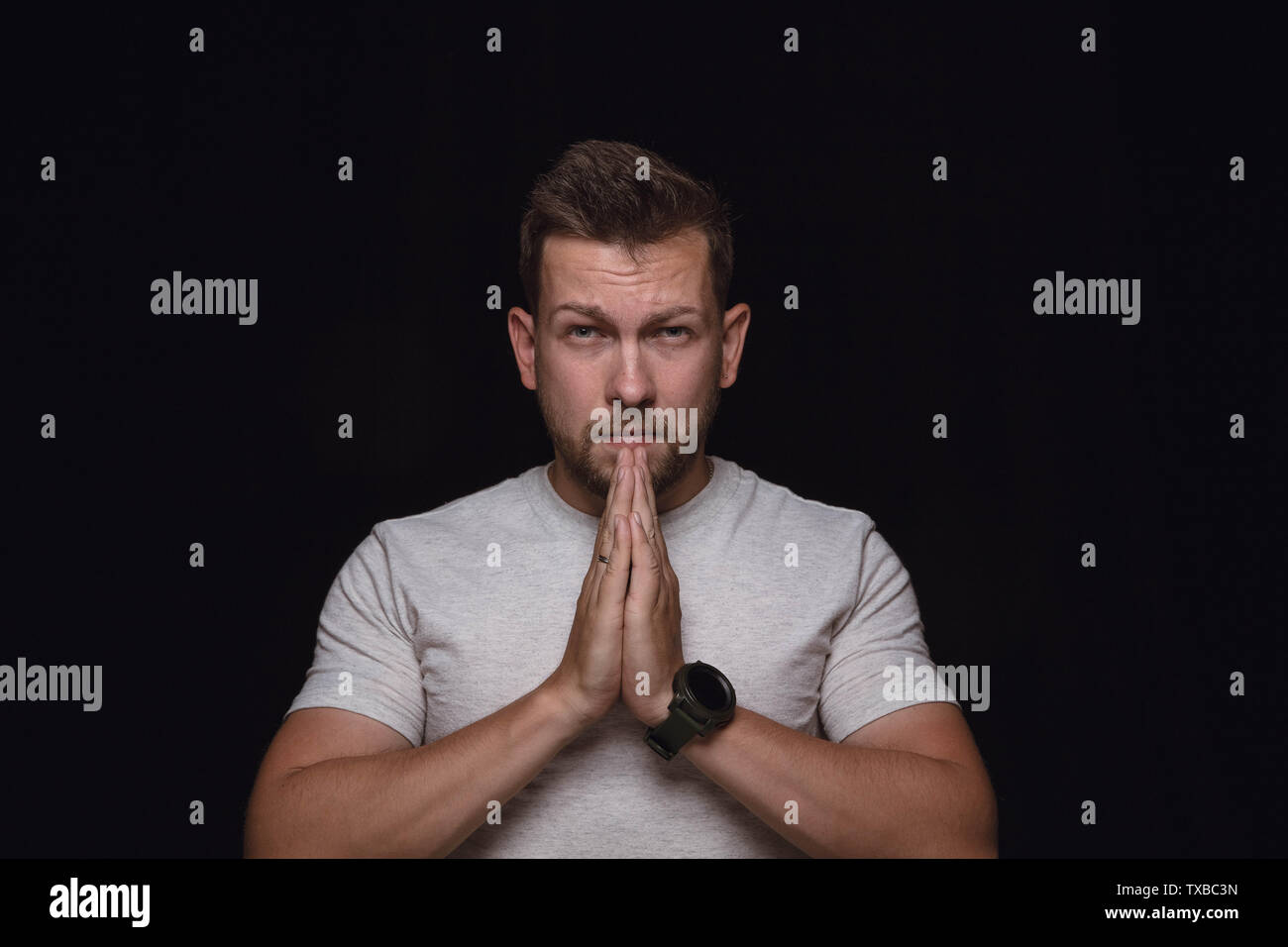 Close up portrait of young man isolated on black studio background ...