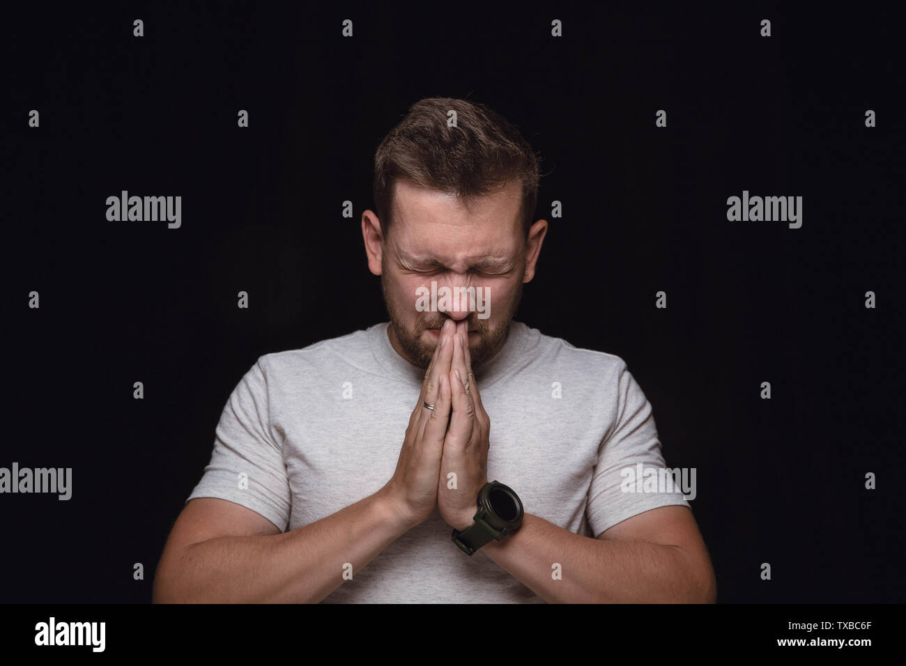 Close up portrait of young man isolated on black studio background ...