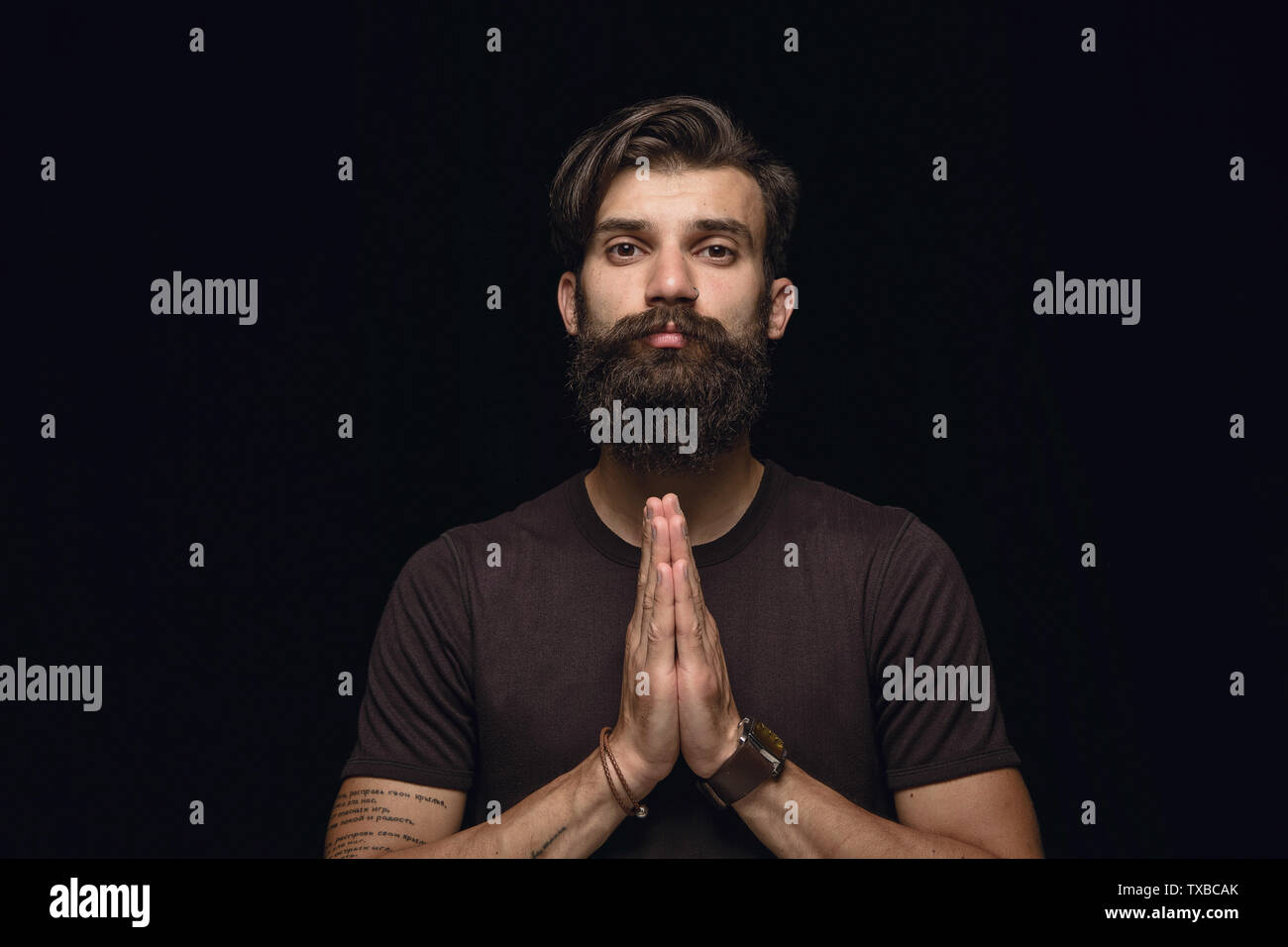 Close up portrait of young man isolated on black studio background ...