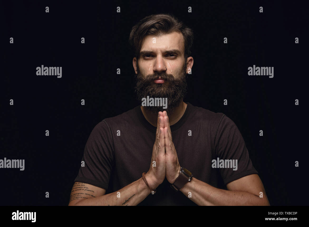 Close up portrait of young man isolated on black studio background ...
