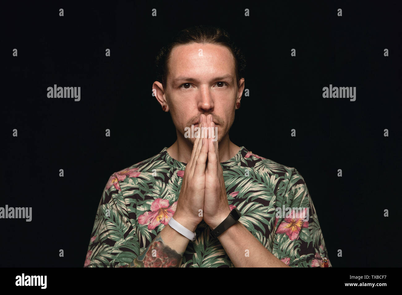 Close up portrait of young man isolated on black studio background ...