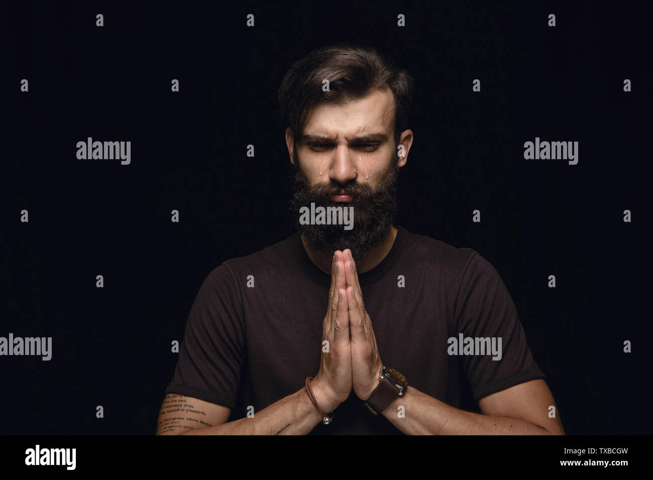 Close up portrait of young man isolated on black studio background ...