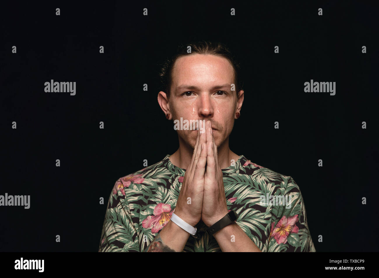 Close up portrait of young man isolated on black studio background ...
