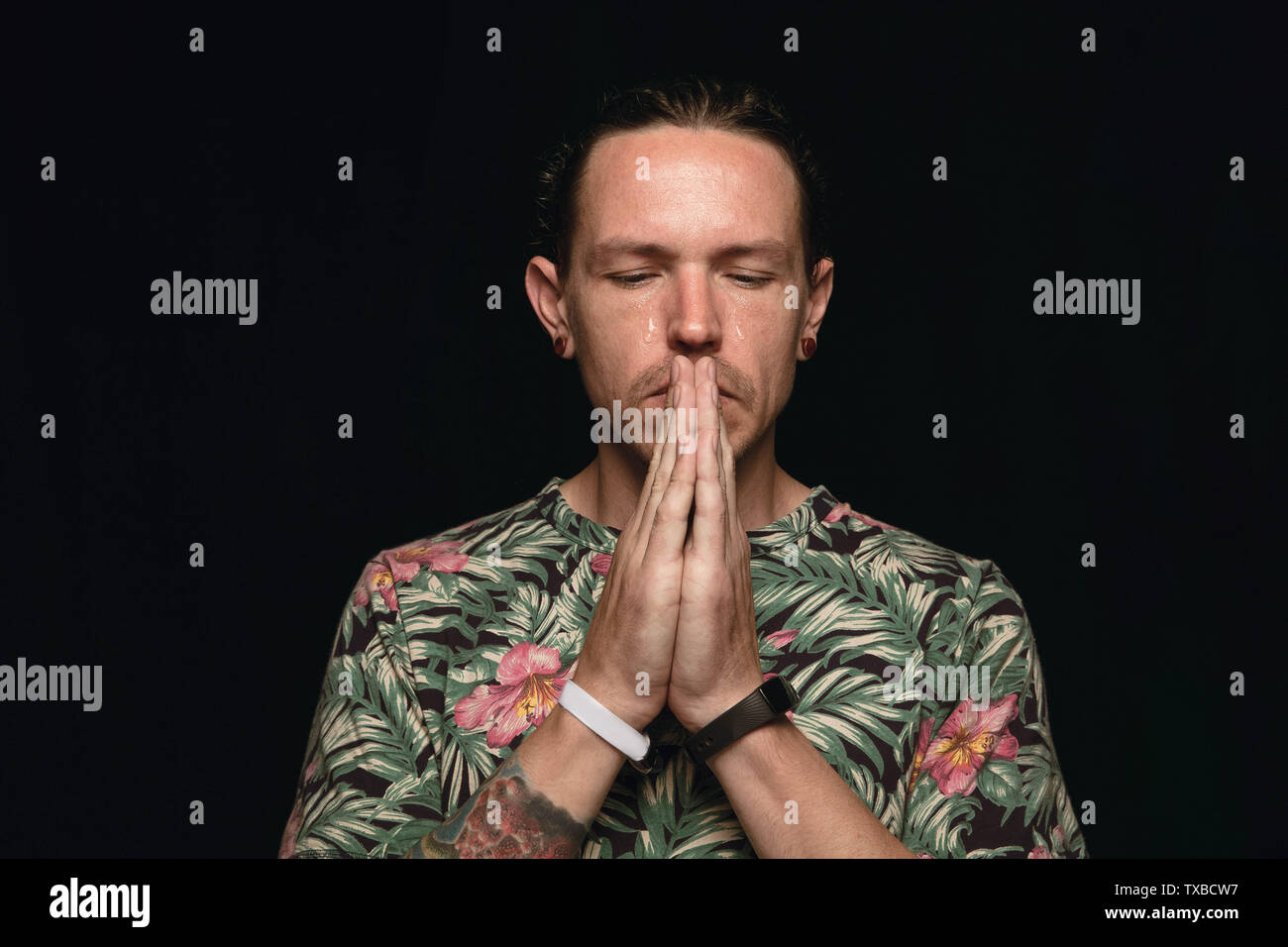 Close up portrait of young man isolated on black studio background ...