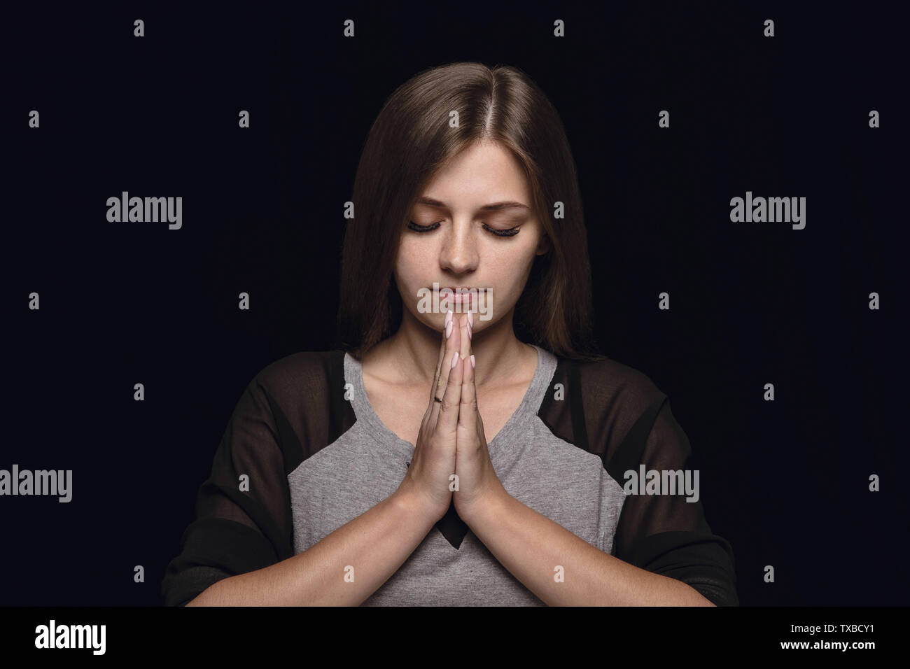 Close up portrait of young woman isolated on black studio background ...