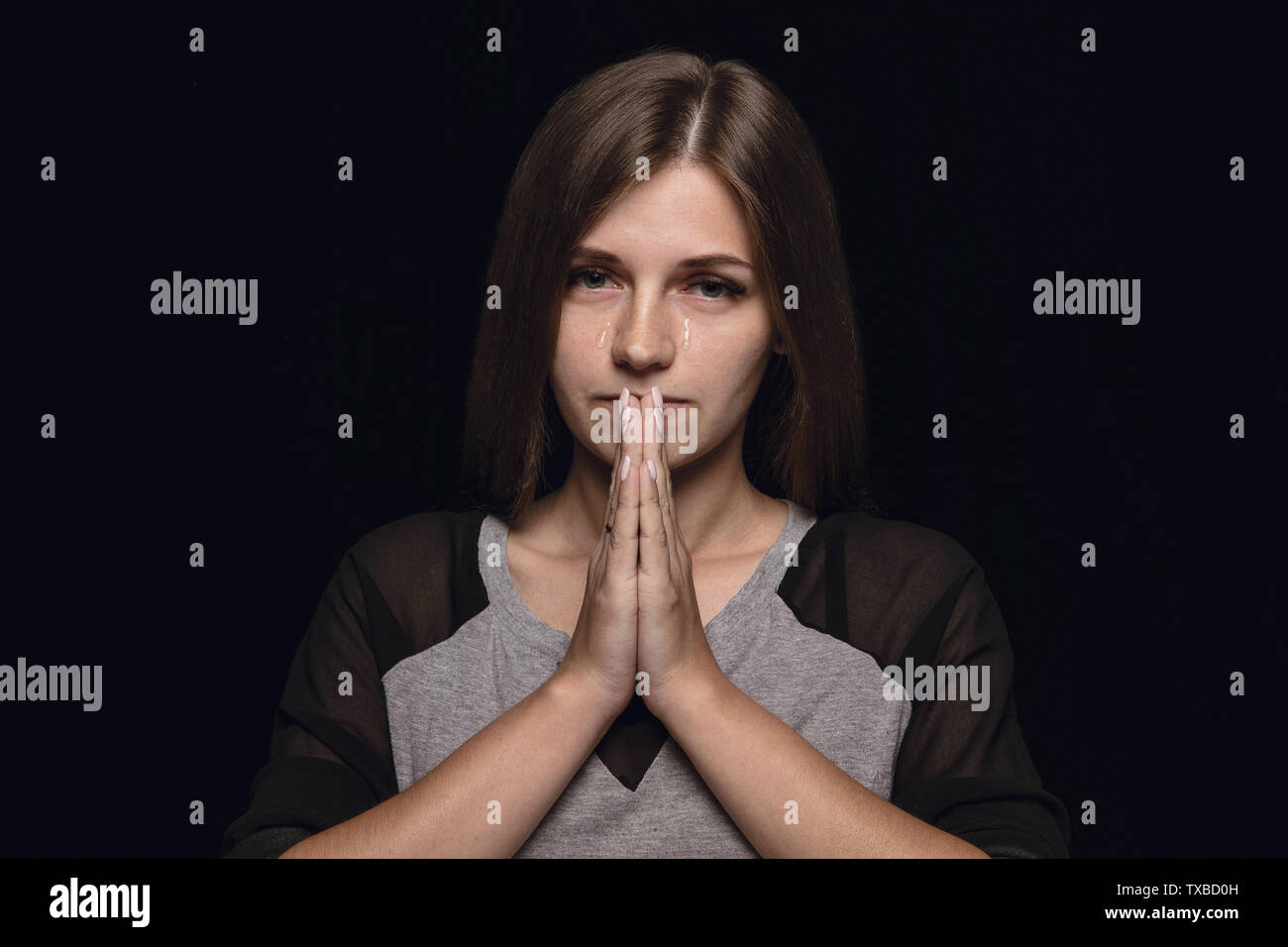 Close up portrait of young woman isolated on black studio background ...