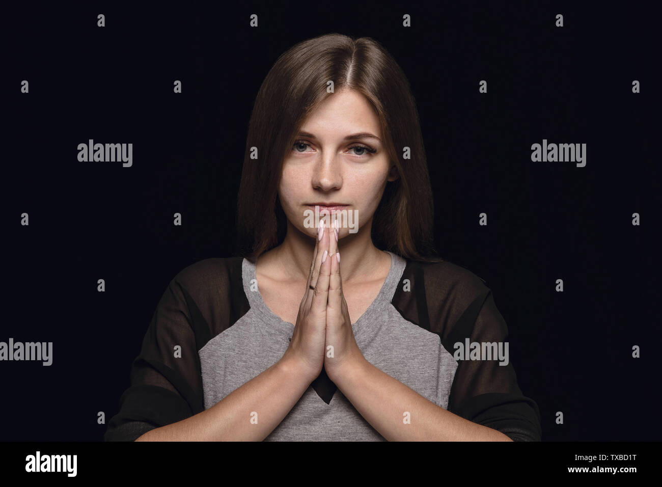 Close up portrait of young woman isolated on black studio background ...