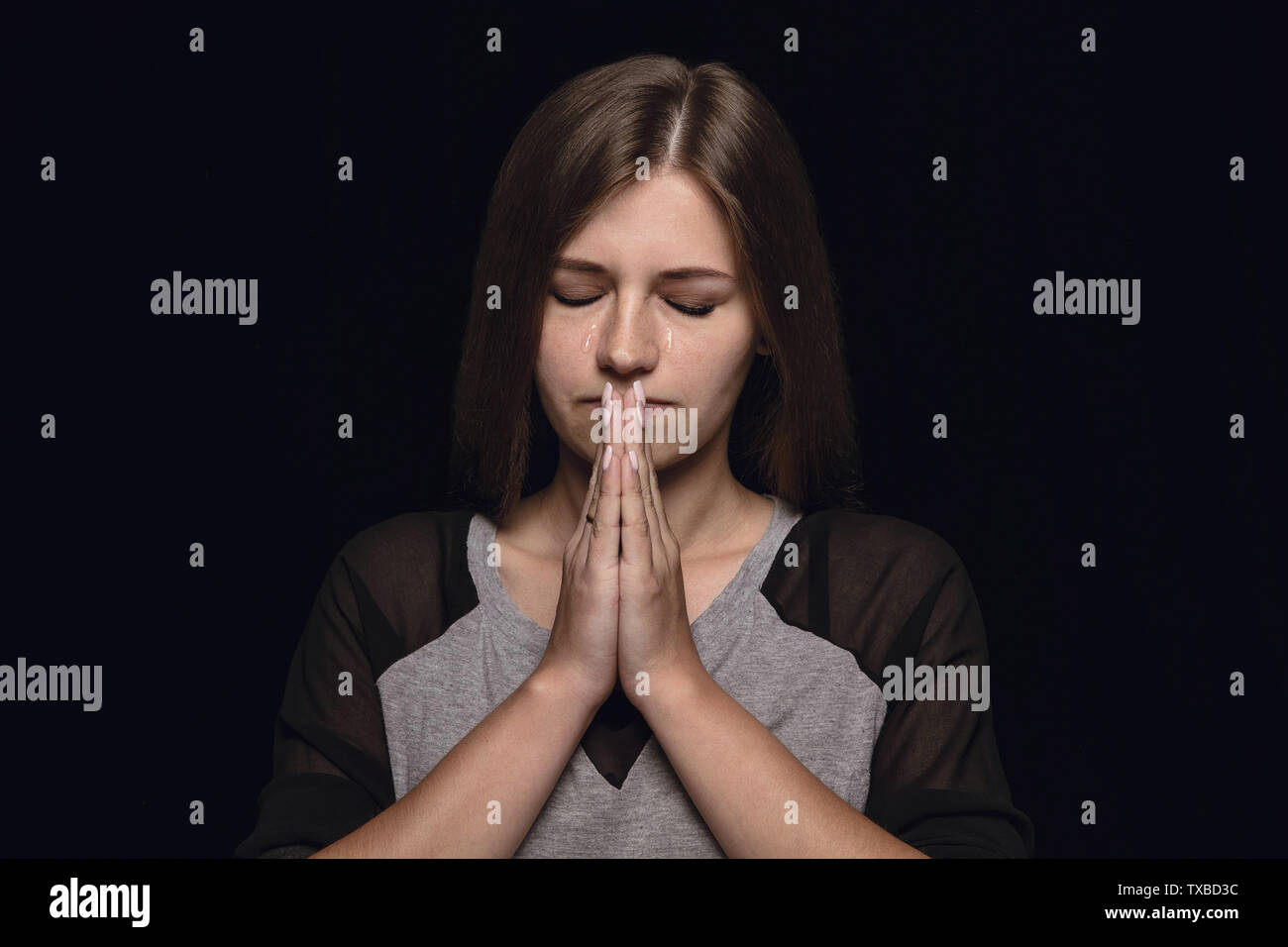 Close up portrait of young woman isolated on black studio background ...
