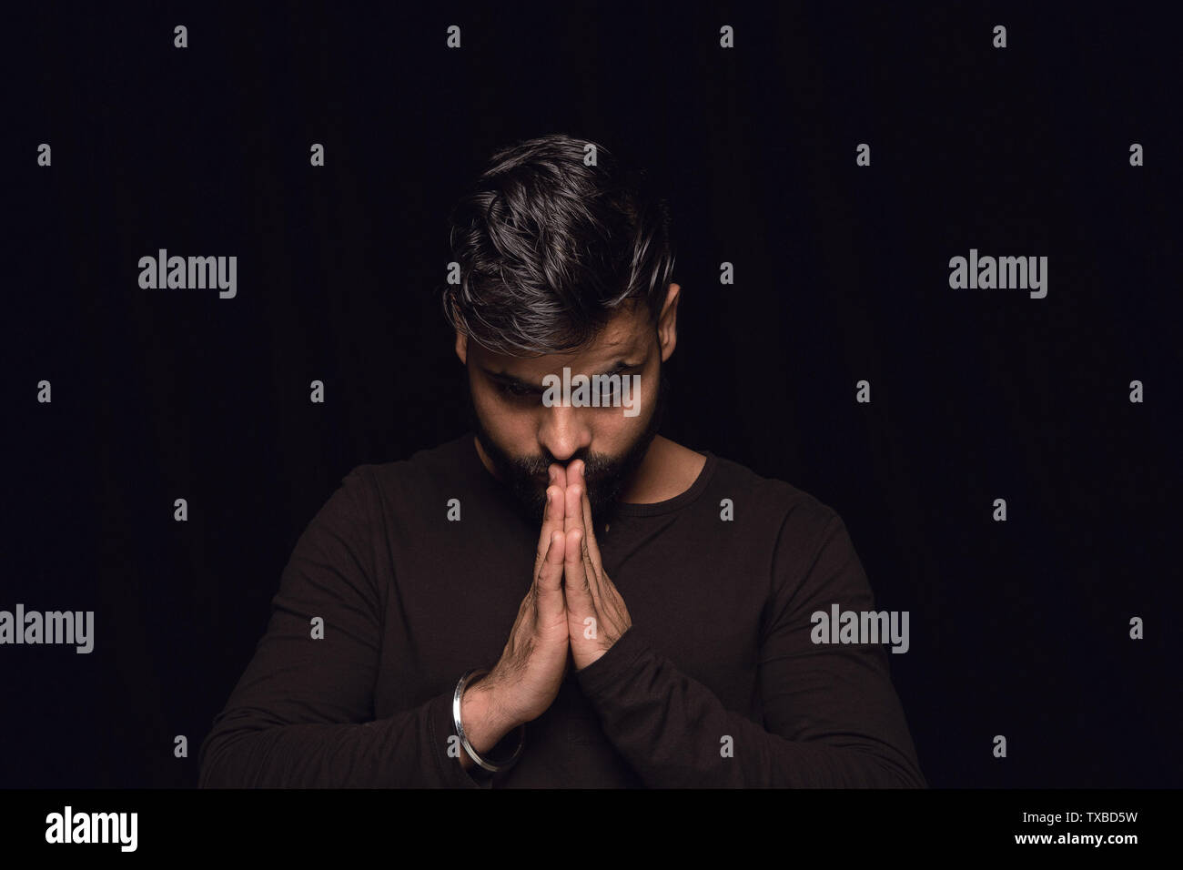 Close up portrait of young man isolated on black studio background ...