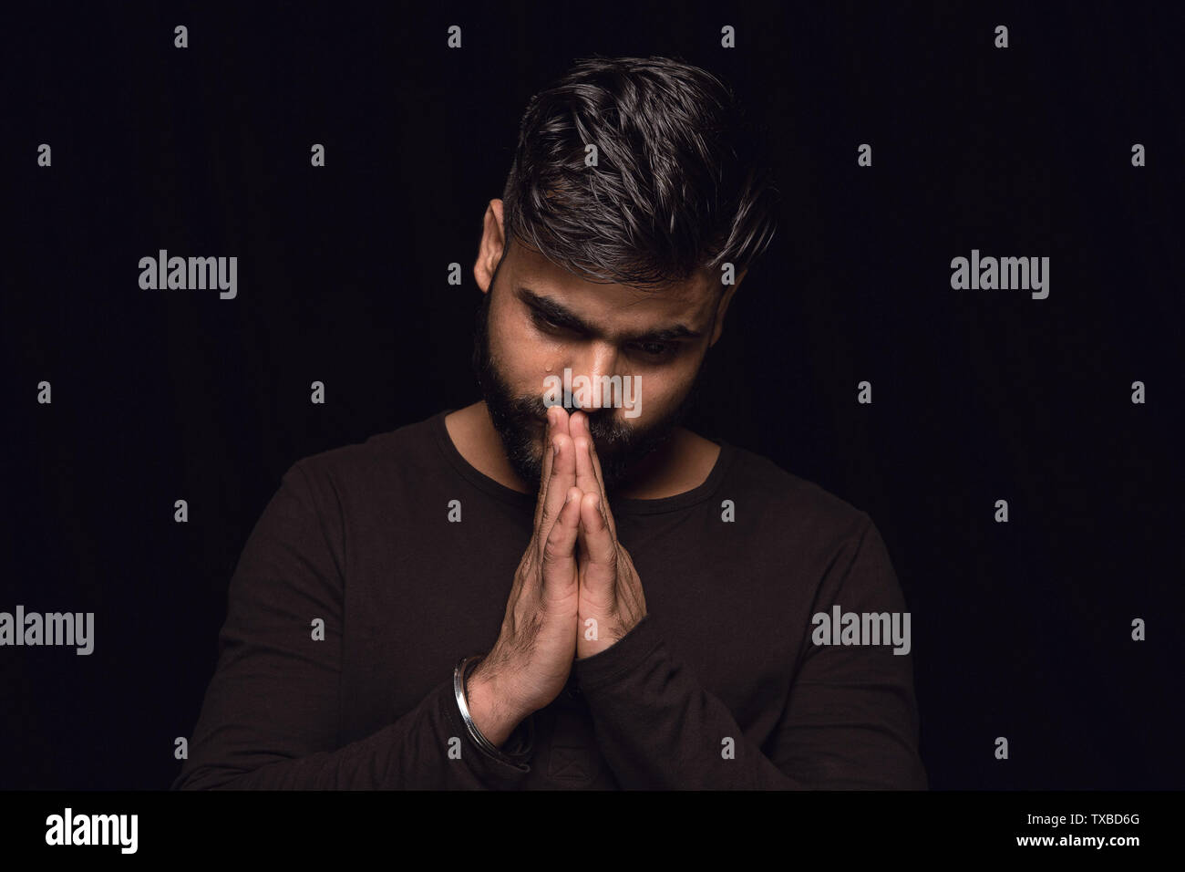 Close up portrait of young man isolated on black studio background ...