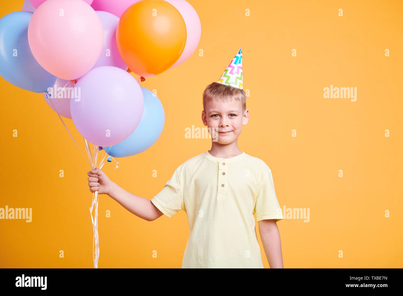 Adorable boy holding bunch of colorful balloons Stock Photo - Alamy
