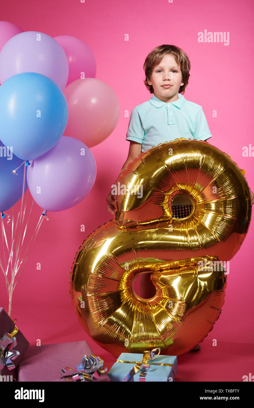Little boy with balloon in shape of number eight Stock Photo - Alamy