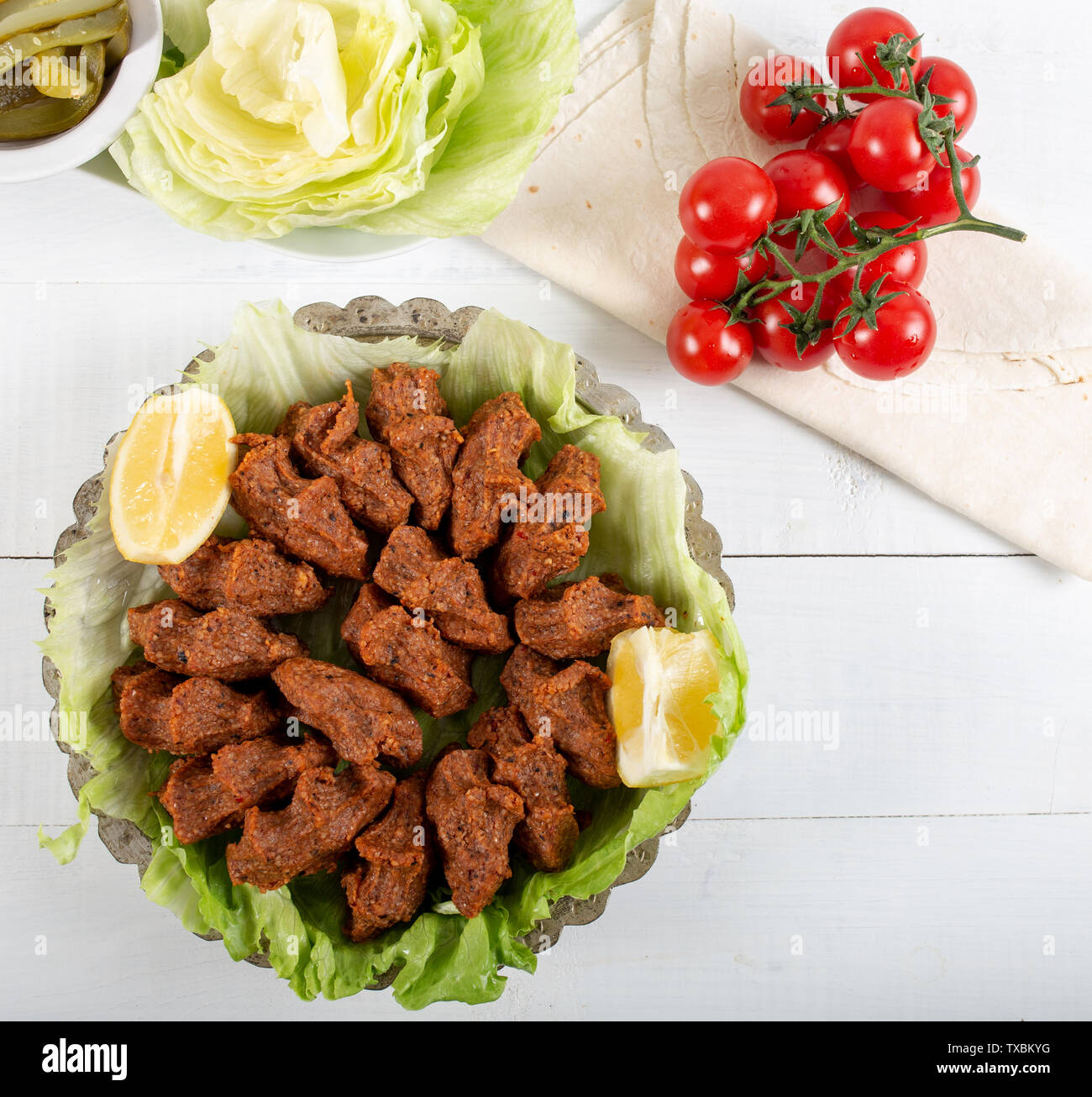 Turkish Food Cig Kofte with lemon, lettuce and parsley on silver plate ...