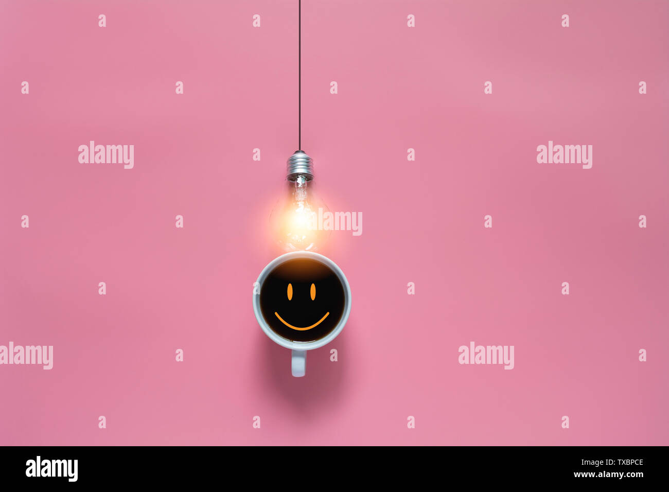 Top view of coffee with light bulb on pink background and copy space ...