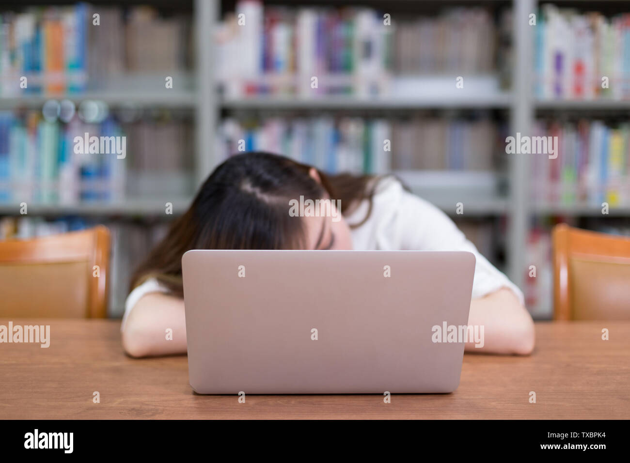 Beautiful Asian female student taking nap during study in librar Stock Photo - Alamy