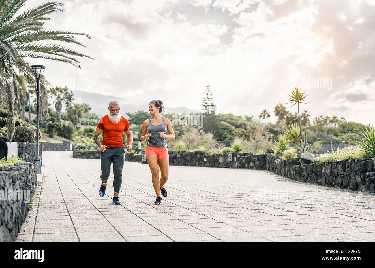 Happy fitness couple running outdoor - Fit joggers friends training ...