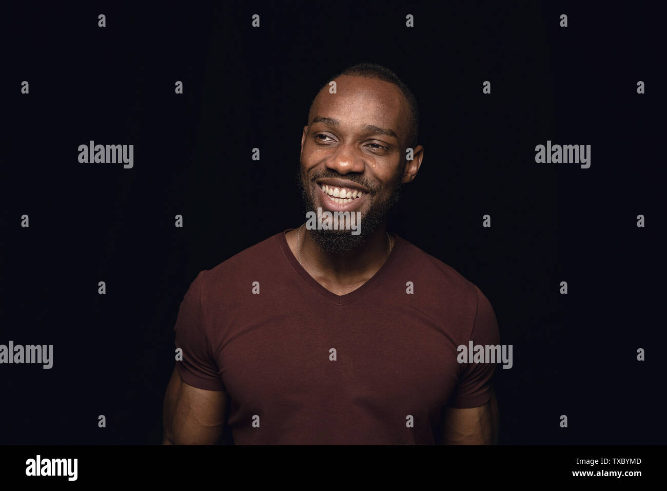 Close up portrait of young man isolated on black studio background ...