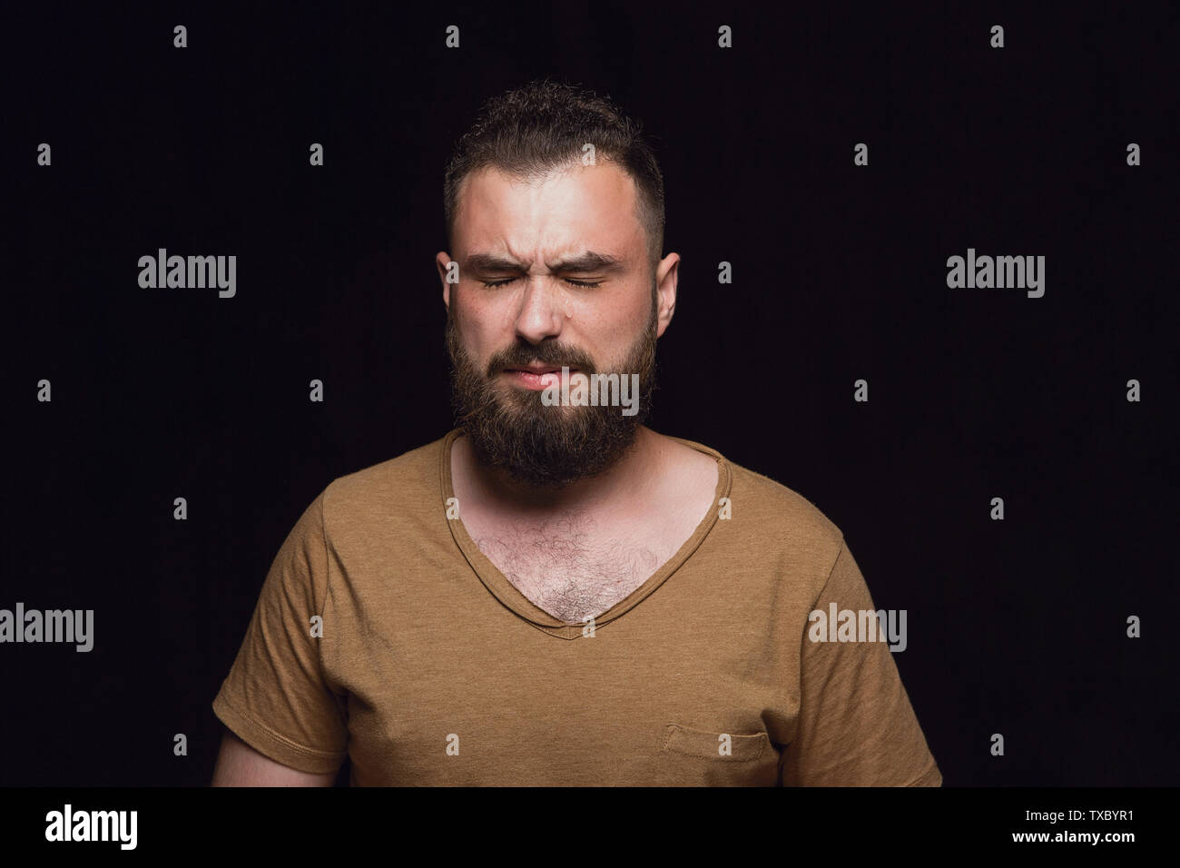 Close up portrait of young man isolated on black studio background ...