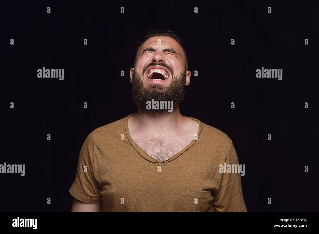 Close up portrait of young man isolated on black studio background ...
