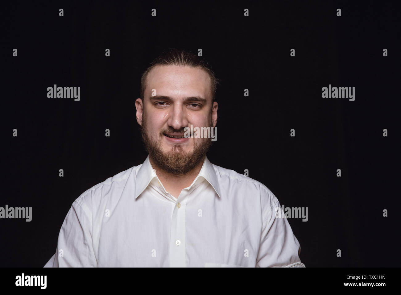 Close up portrait of young man isolated on black studio background ...