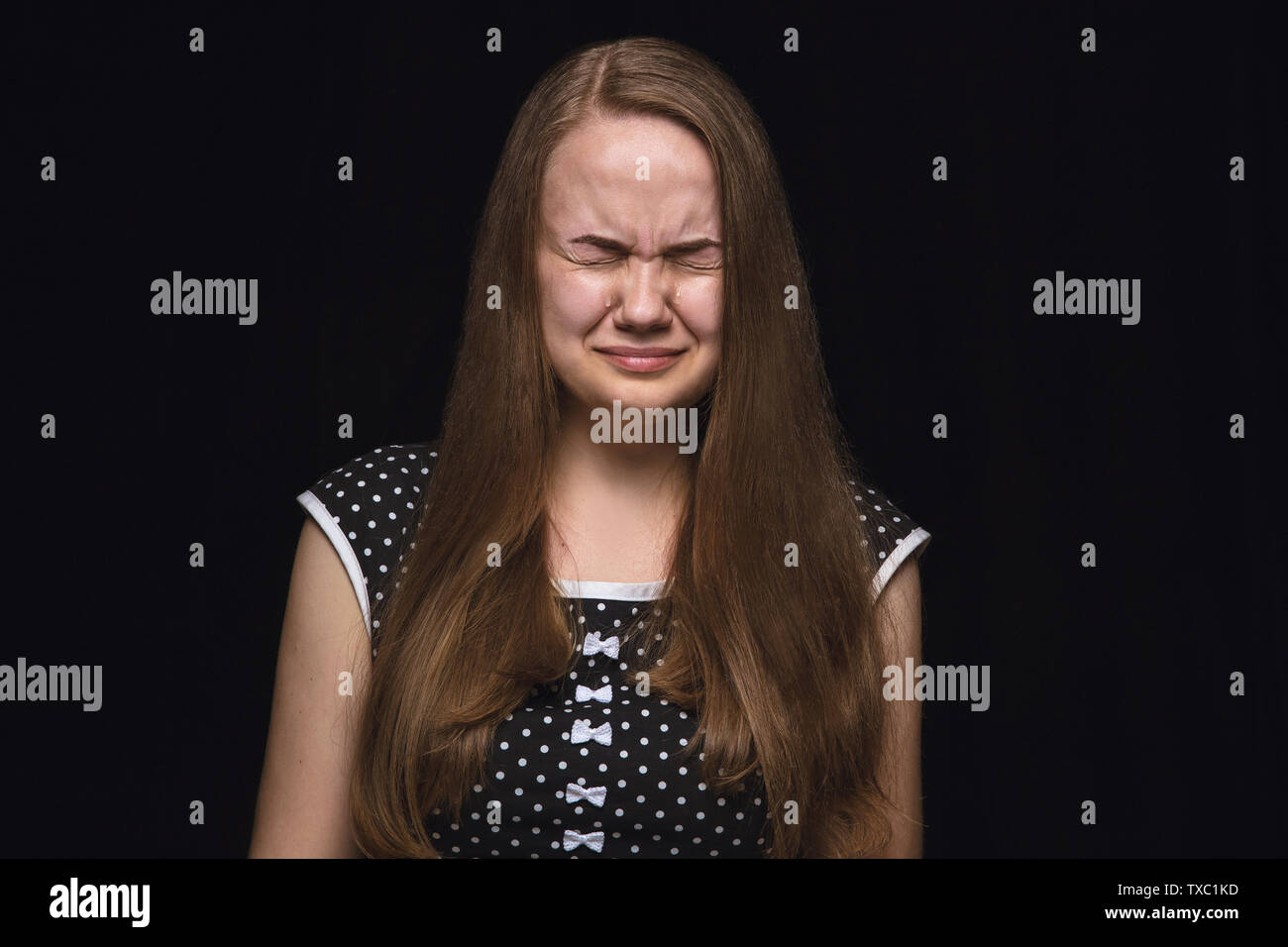 Close up portrait of young woman isolated on black studio background ...