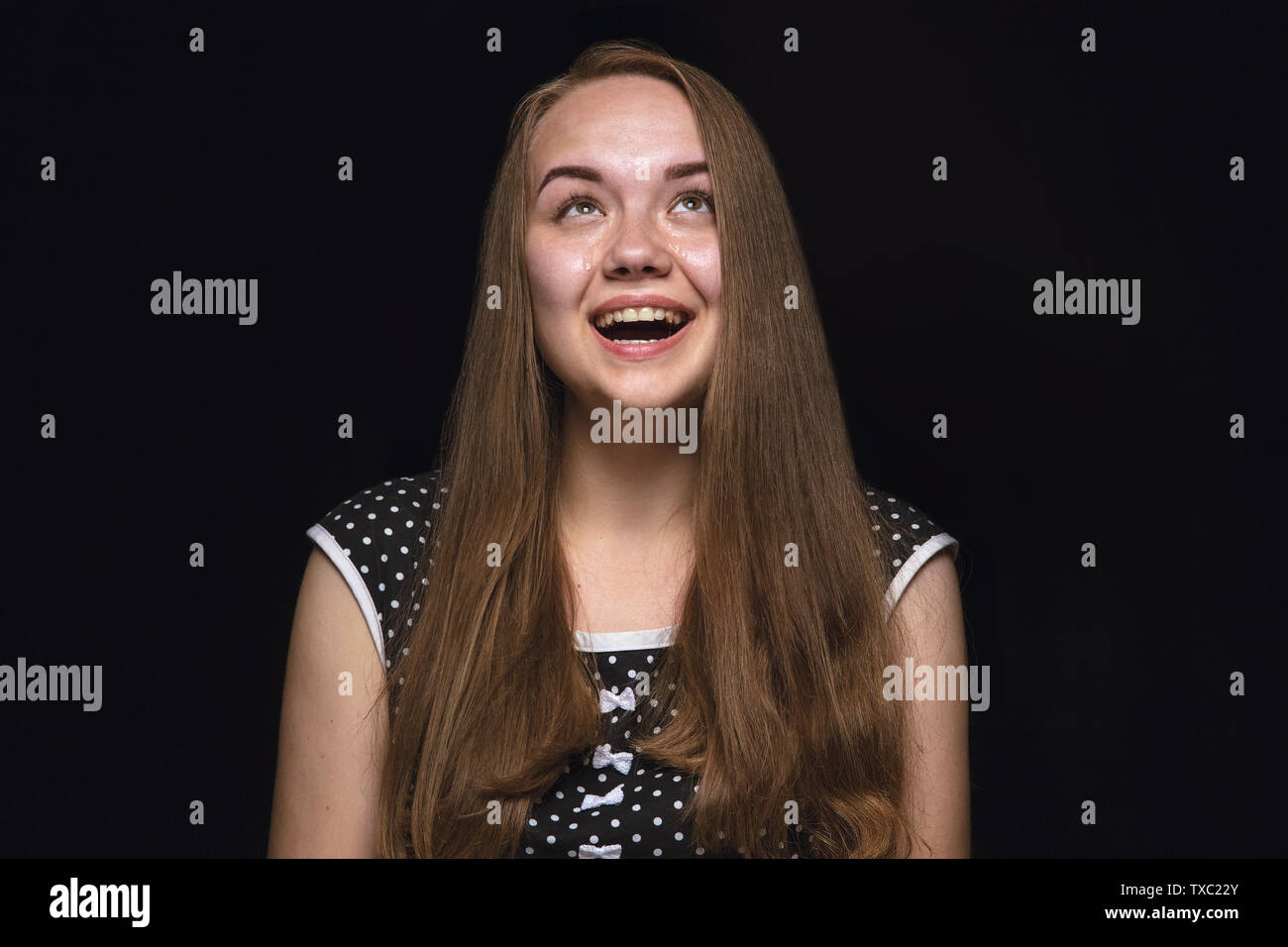 Close up portrait of young woman isolated on black studio background ...