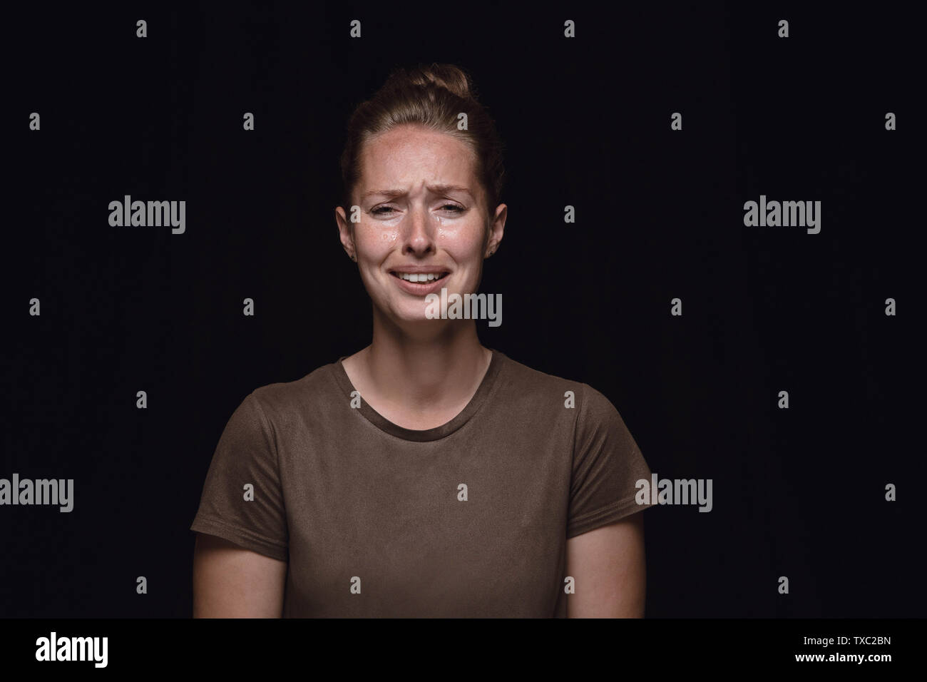 Close up portrait of young woman isolated on black studio background ...