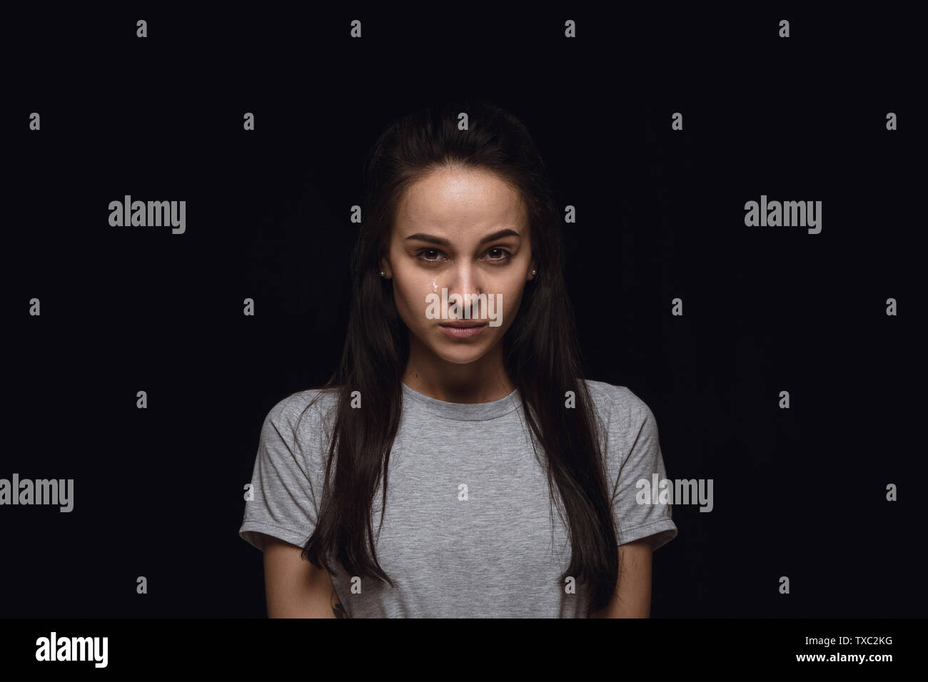 Close up portrait of young woman isolated on black studio background ...