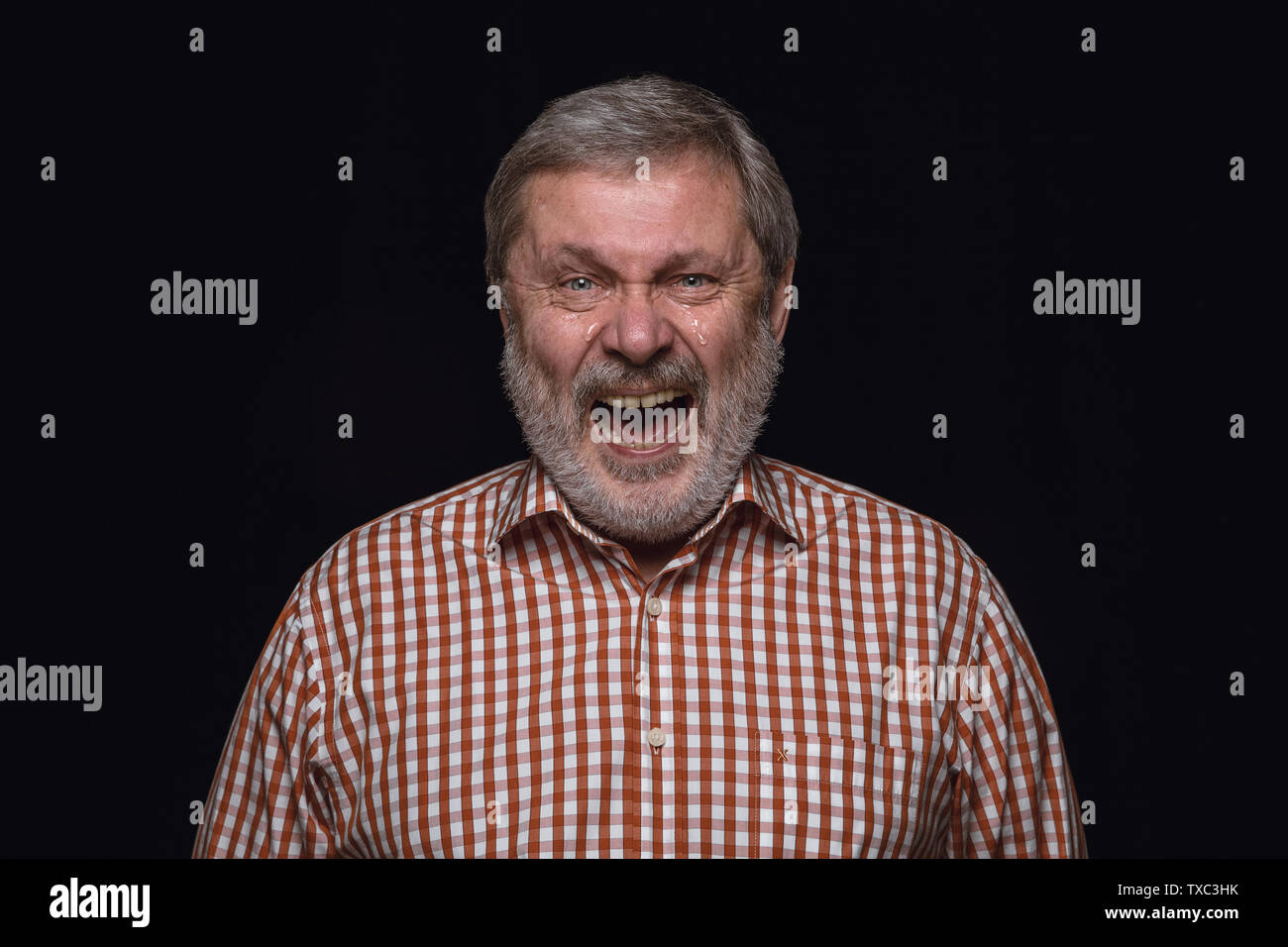 Close up portrait of senior man isolated on black studio background ...
